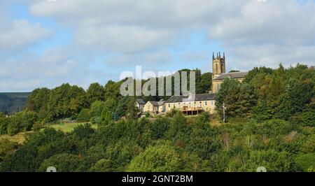 Village of Tintwistle on a Derbyshire hillside church houses and trees ...