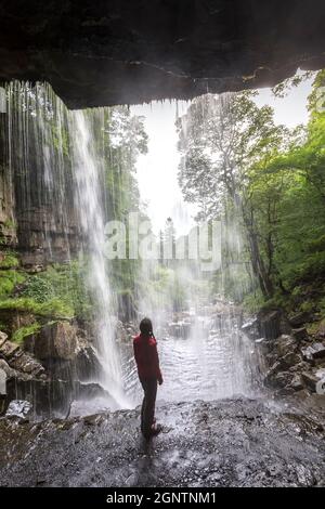Person standing behind Ashgill Force waterfall, Alston, Cumbria, UK ...