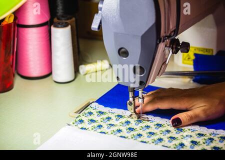 In this photo illustration a seamstress working on a sewing machine at ...
