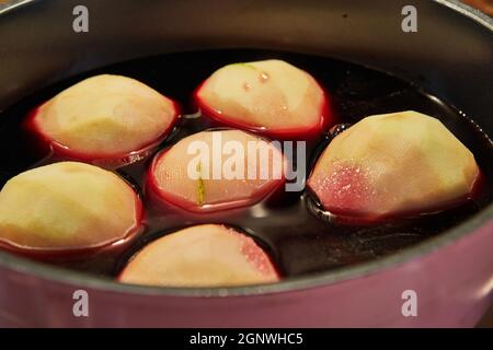 Pears are boiled in red syrup with wine on gas stove Stock Photo - Alamy