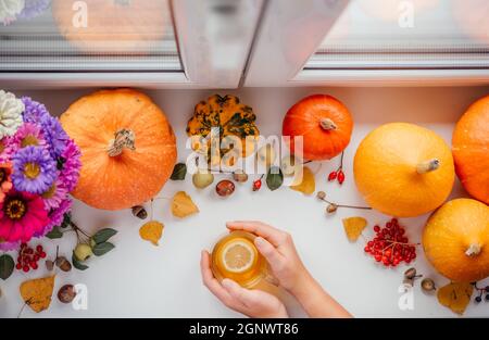 Autumn creative layout with pumpkins, lemon tea, acorns and guelder ...