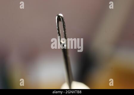 Small needle with empty eyelet, isolated over the black background ...