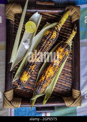 spicy sweet corn burn in fire with lemon and salt in a wood tray from ...