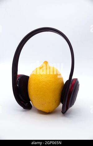 Yellow lemon in headphones on a white background Stock Photo - Alamy