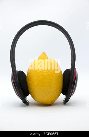 Yellow lemon in headphones on a white background Stock Photo - Alamy