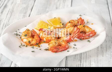 Cooked shrimps with thyme and lemon wedges on serving plate Stock Photo ...