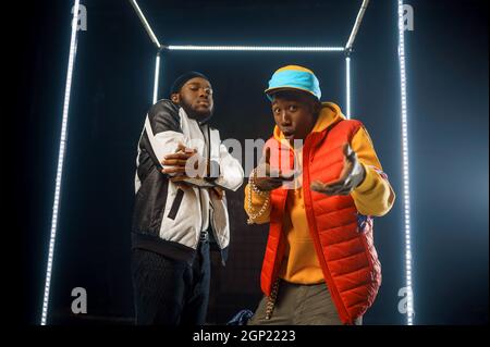 Two stylish rappers poses in glowing cube Stock Photo - Alamy