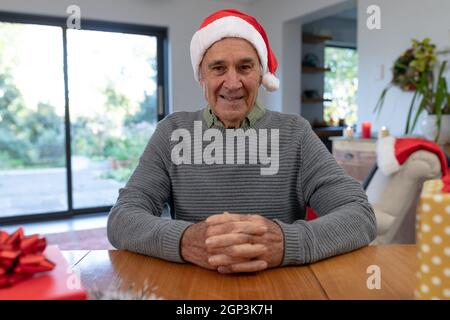 Caucasian man with santa hat having video call with santa claus with ...