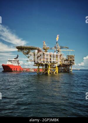 offshore support vessel stand by near oil platform at sea Stock Photo ...