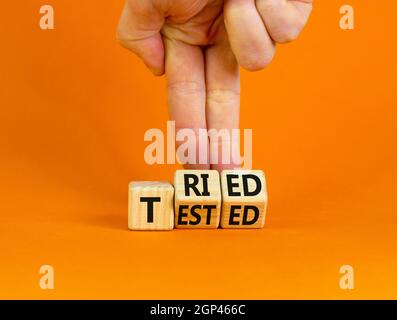 Tried and tested symbol. Businessman turns wooden cubes and changes the ...