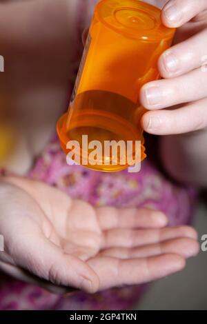 Woman dumping medication from a bottle into her hand Stock Photo - Alamy
