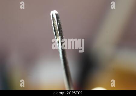 Small needle with empty eyelet, isolated over the black background ...