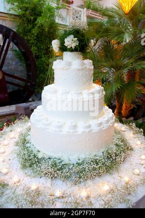 A closeup of small 2 tiered wedding cake with gold sequins and edible ...