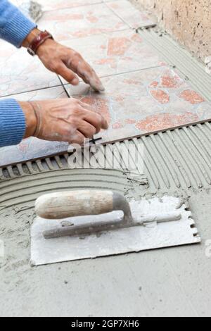 Tiler to work with tile flooring for garden Stock Photo - Alamy