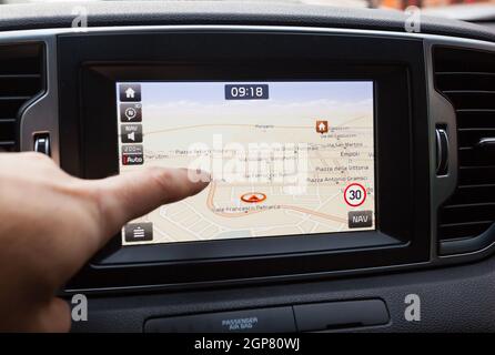 GPS navigation panel on dashboard inside a car. Finger pointing on ...