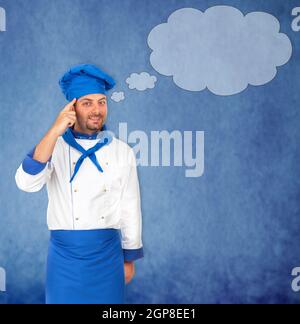 Young chef think on blue background Stock Photo - Alamy