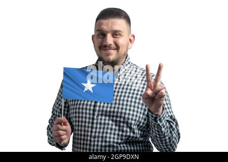 White guy holding a flag of Somalia and with a serious face shows a ...
