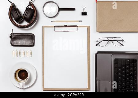 Flat lay of stylish male workplace with clip folder, laptop and ...
