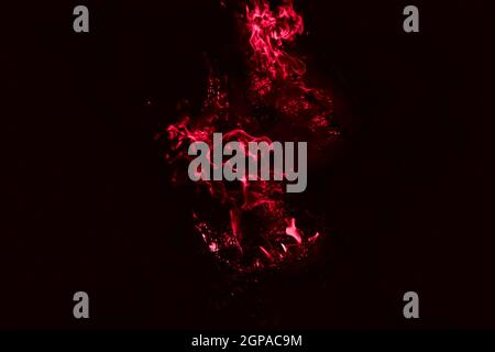 A dark red flame. Burning of rice straw at night Stock Photo - Alamy