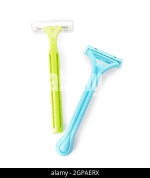 top view of green and pink razors and depilation wax stripes on white ...