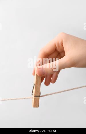 Young woman with clothespin on light grey background. Runny nose ...