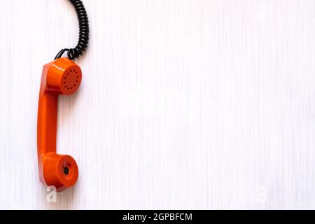 Orange phone handle hanging down on a cord. Urgent business. Unsolved ...