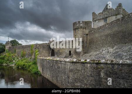 Tall stone walls and moat of 11th century Cahir castle in Cahir town ...