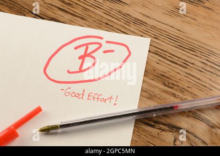 A graded school paper marked in red ink over a wood desktop Stock Photo ...