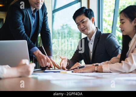 Multiracial business people gather to discuss the company's market plan ...