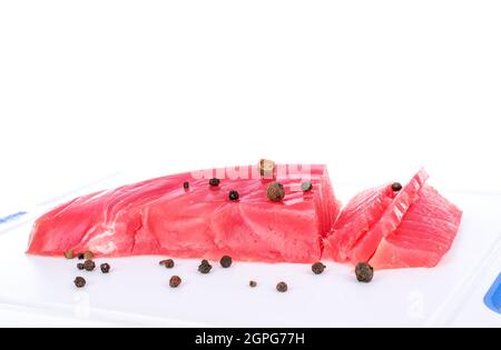 One piece of slightly salted tuna meat on a cutting board, close-up ...