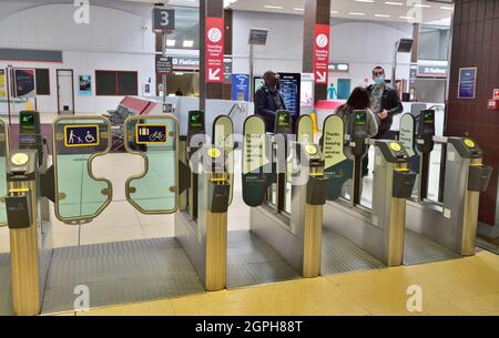 Train station ticket barriers gate across train platform big bold green ...