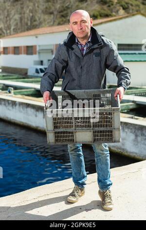 Portrait of man fish farm owner demonstrating freshly caught fish Stock ...