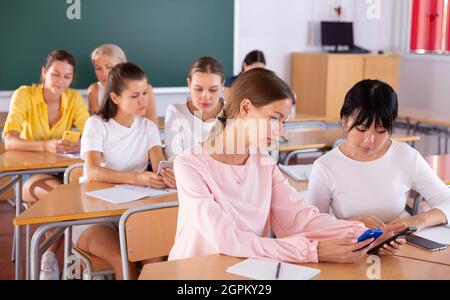 Students working in pairs using phones Stock Photo - Alamy