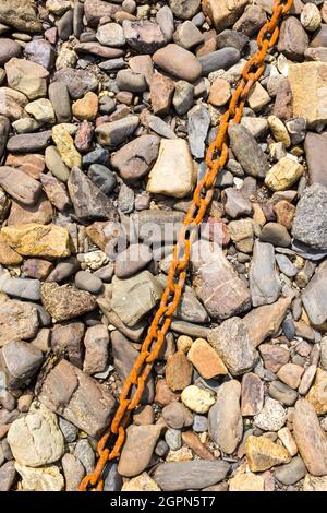 Close-up of rusty anchor and damaged metallic chain on ocean floor ...
