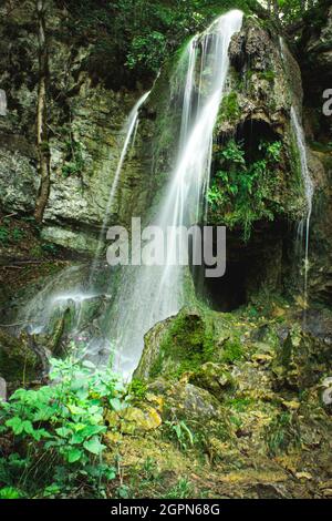 A long exposure shot of a small waterfall full of rocks in the daylight ...