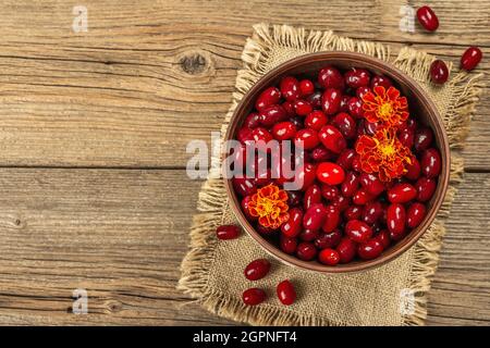 Ripe dogwood berry with bright marigold flowers. Fresh red Cornus in a ...