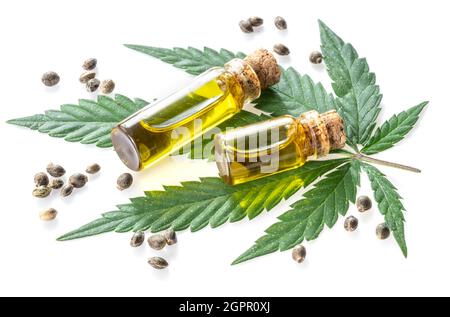 Cannabis leaf and small bottles of hemp oil isolated on white ...