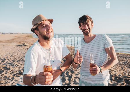 Two friends hug each other at the sunset on the beach. Friendship and ...