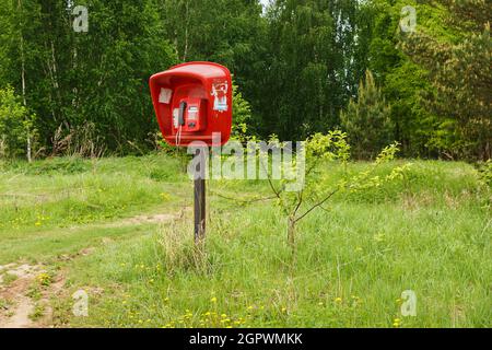 red payphone. Payphone standing in the field. Village telephone. Russia ...