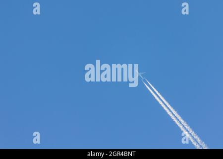 Flying plane leaves an inversion trail in the air Stock Photo - Alamy