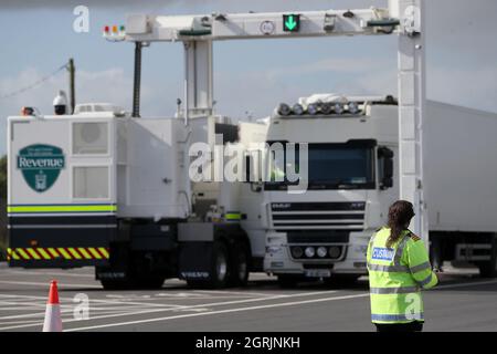 A customs official watches as a truck is scanned by a Customs X-Ray ...