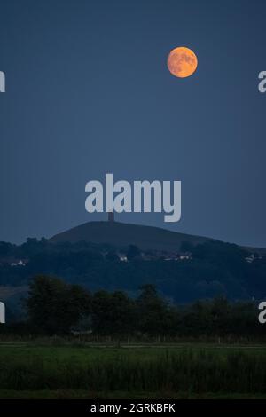 Glastonbury Tor from the moors at sunset. With a full moon rising Stock ...