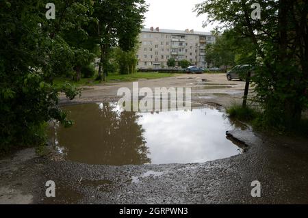 Kovrov, Russia. 3 July 2017. Puddle on the road in the courtyard with ...