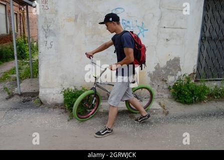 Kovrov, Russia. 15 July 2017. Teen on BMX bike performs a trick in park named Degtyarev Stock ...
