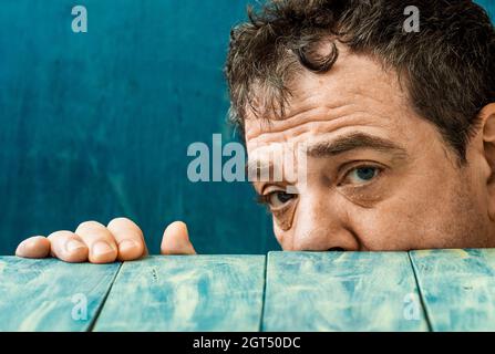 Scared man hiding under table in living room during earthquake Stock ...