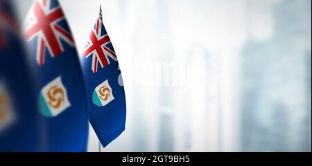 Small flags of Anguilla on a blurry background of the city Stock Photo ...