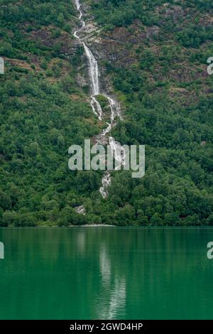 OLDEN, NORWAY- 2020 JUNE 20. Waterfall with rainbow next to the bridge ...