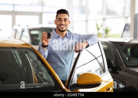 Cheerful arab businessman driving nice car, side view Stock Photo - Alamy