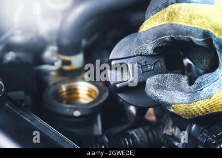 Mechanic hand open an oil filler cap of the engine car Stock Photo - Alamy