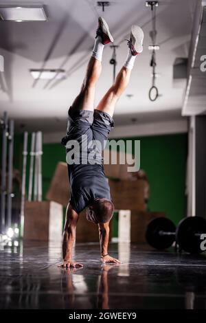 Muscular athlete standing and walking on hands upside down Stock Photo ...